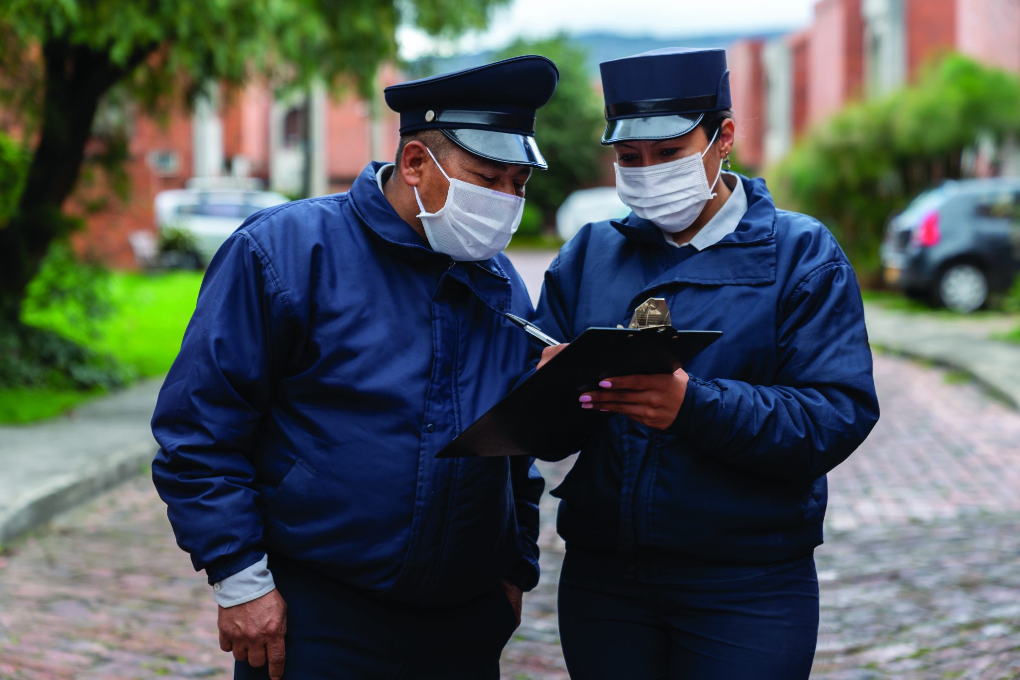 Team of security guards working together wearing facemasks - Police ...