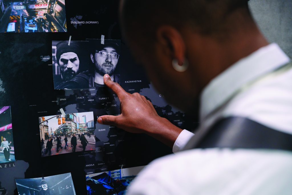 Portrait of a thoughtful dark-skinned man looking at a map of the world ...