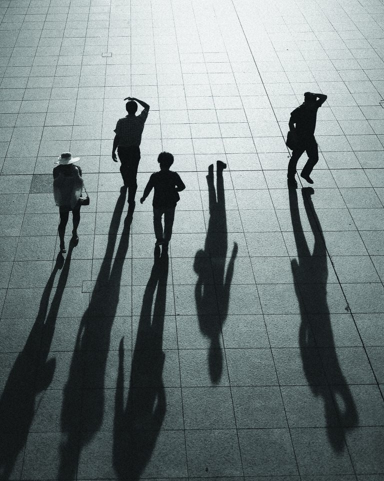 High Angle View Of People Walking With Long Shadows On Footpath In City ...