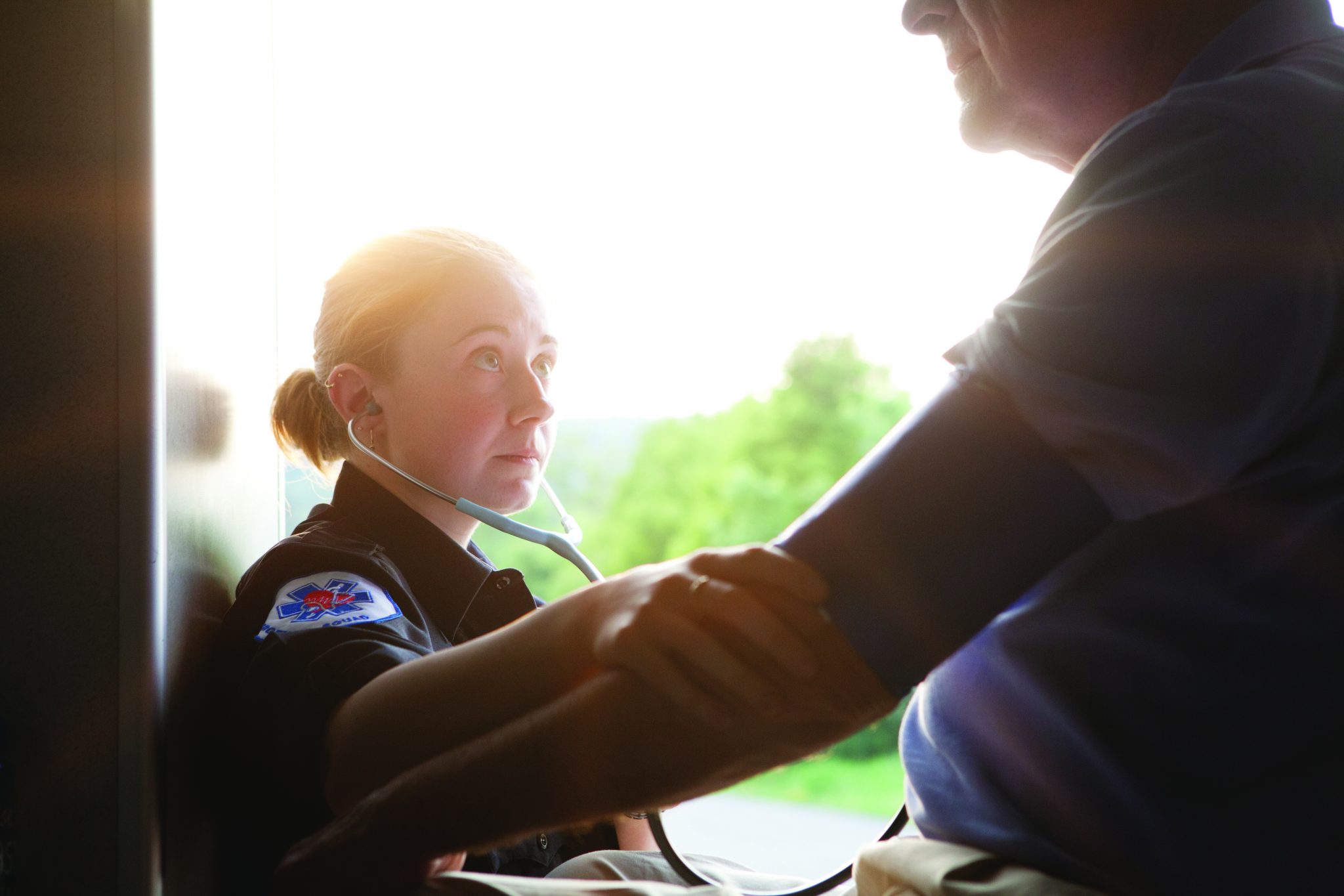 Close-up of paramedic checking mans blood pressure in ambulance ...